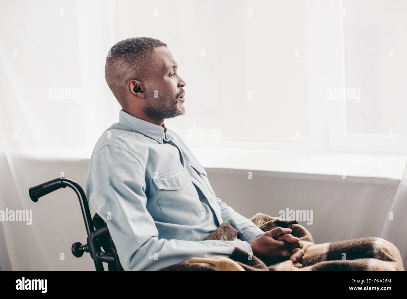 Side View Of Senior African American Man Sitting In Wheelchair And
