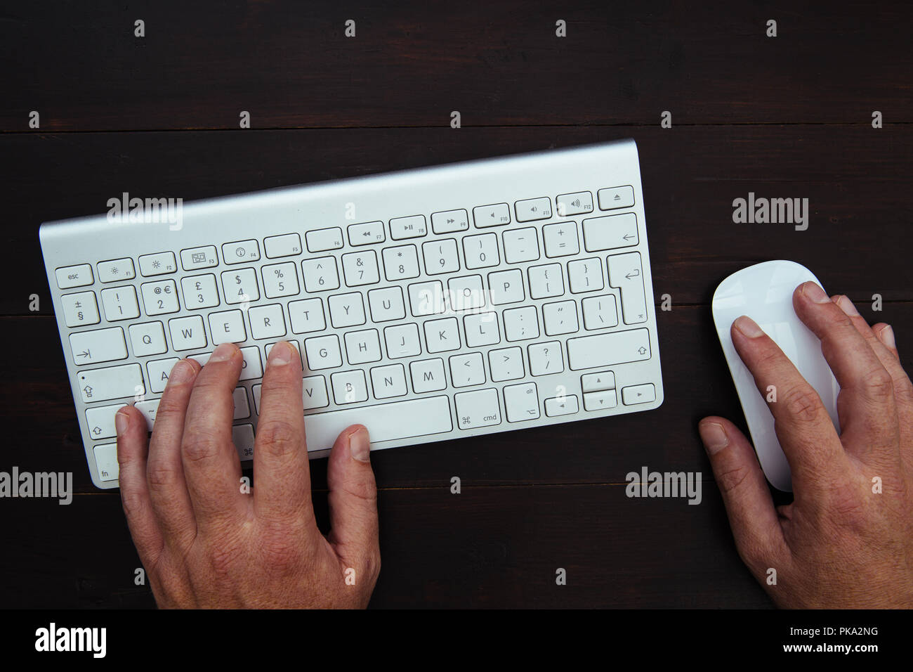 Man working at office desk with computer keyboard and mouse Stock Photo ...
