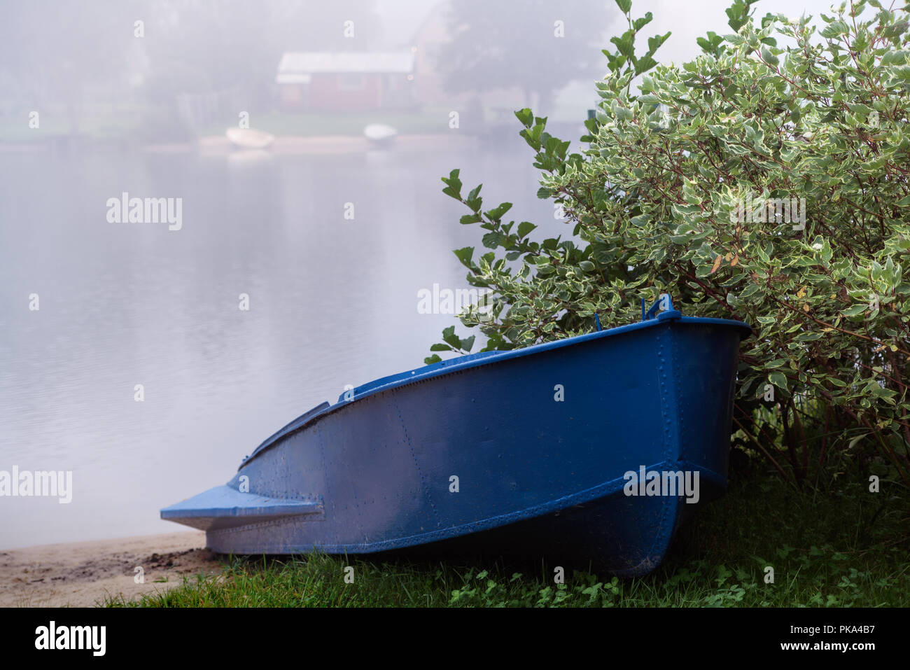 Blue iron boat on the bank of the river in a misty morning Stock Photo ...