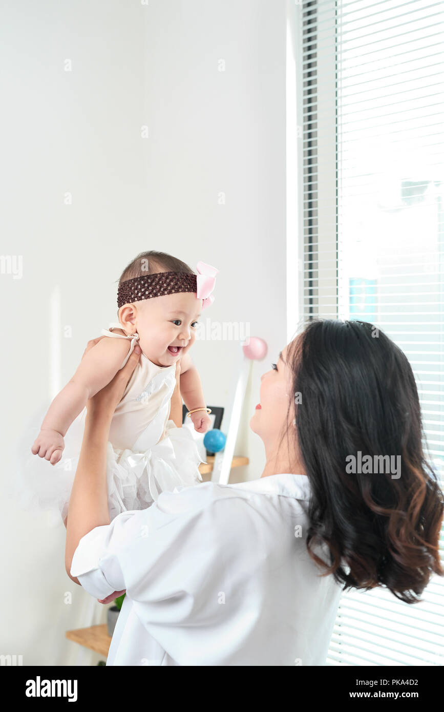 family, child and parenthood concept - happy smiling young mother with little baby at home Stock ...