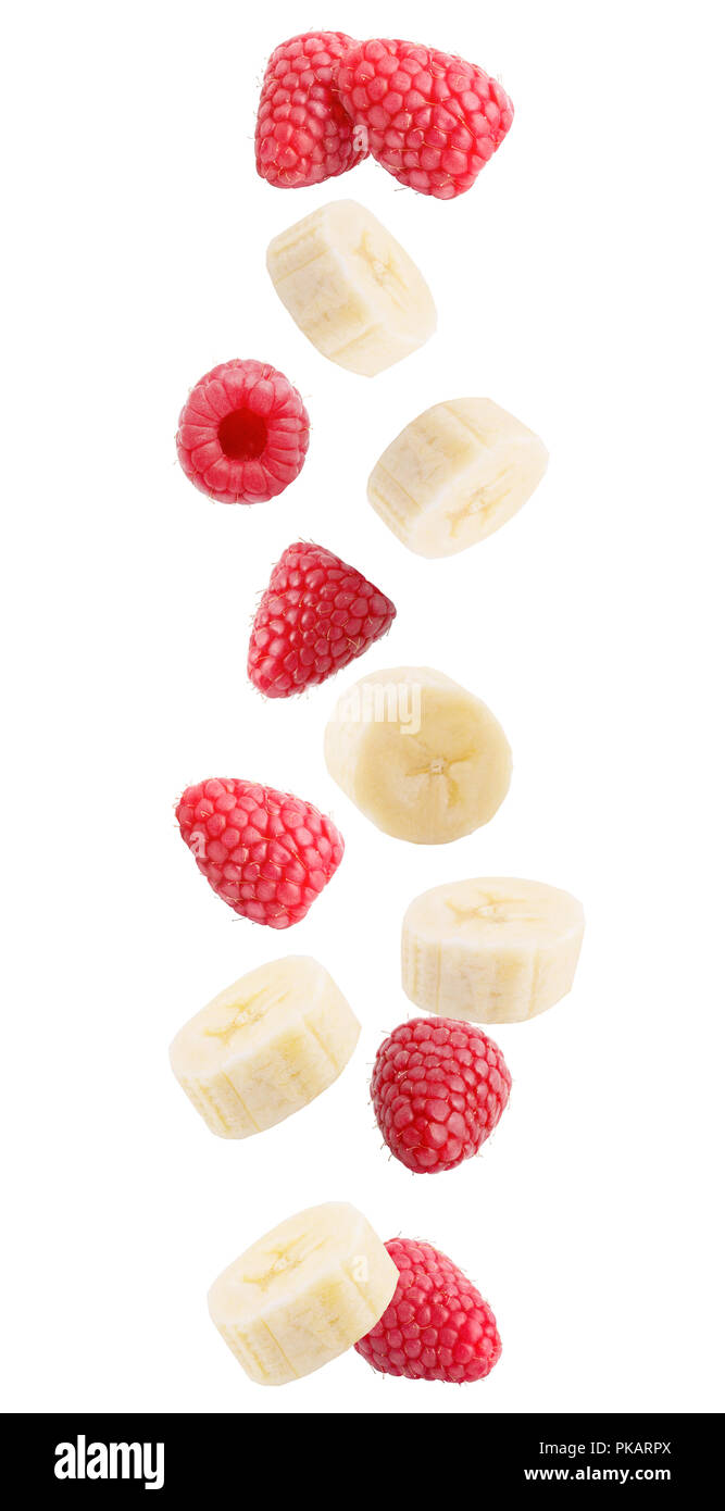 Isolated flying fruits. Falling banana and raspberries isolated on ...