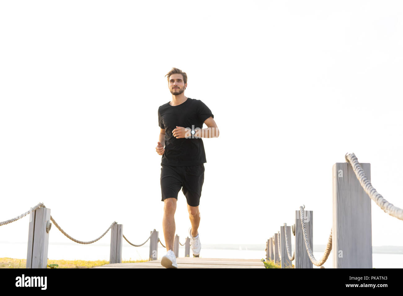 Full length shot of healthy young man running on the promenade. Male ...