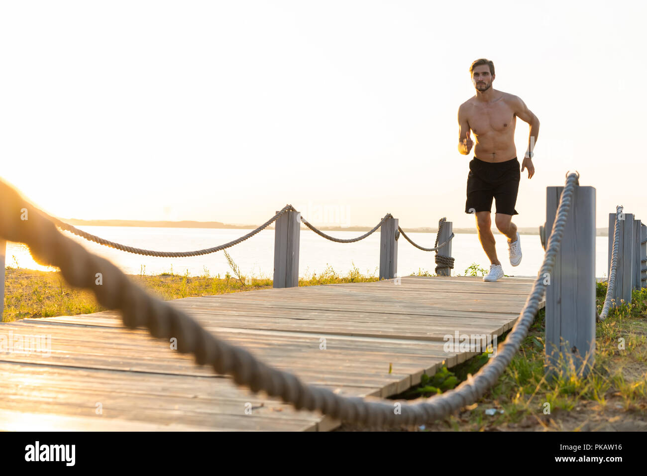 Full length shot of healthy young man running on the promenade. Male ...