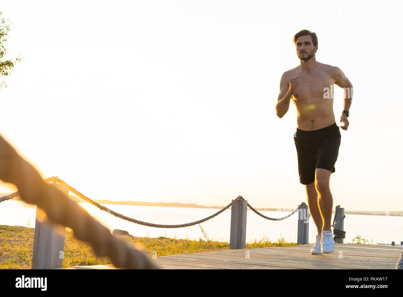 Full length shot of healthy young man running on the promenade. Male ...