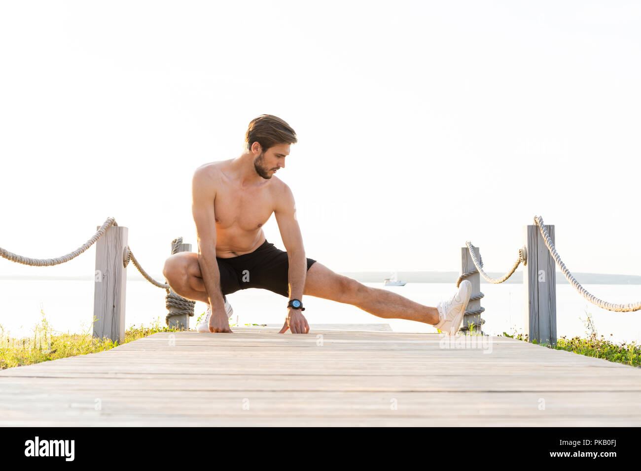 Portrait Of Handsome Young Man Stretching Legs Before Exercise Run