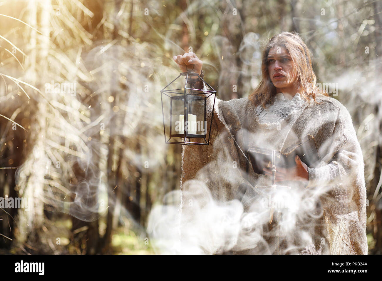 A man in a cassock spends a ritual in a dark forest Stock Photo - Alamy