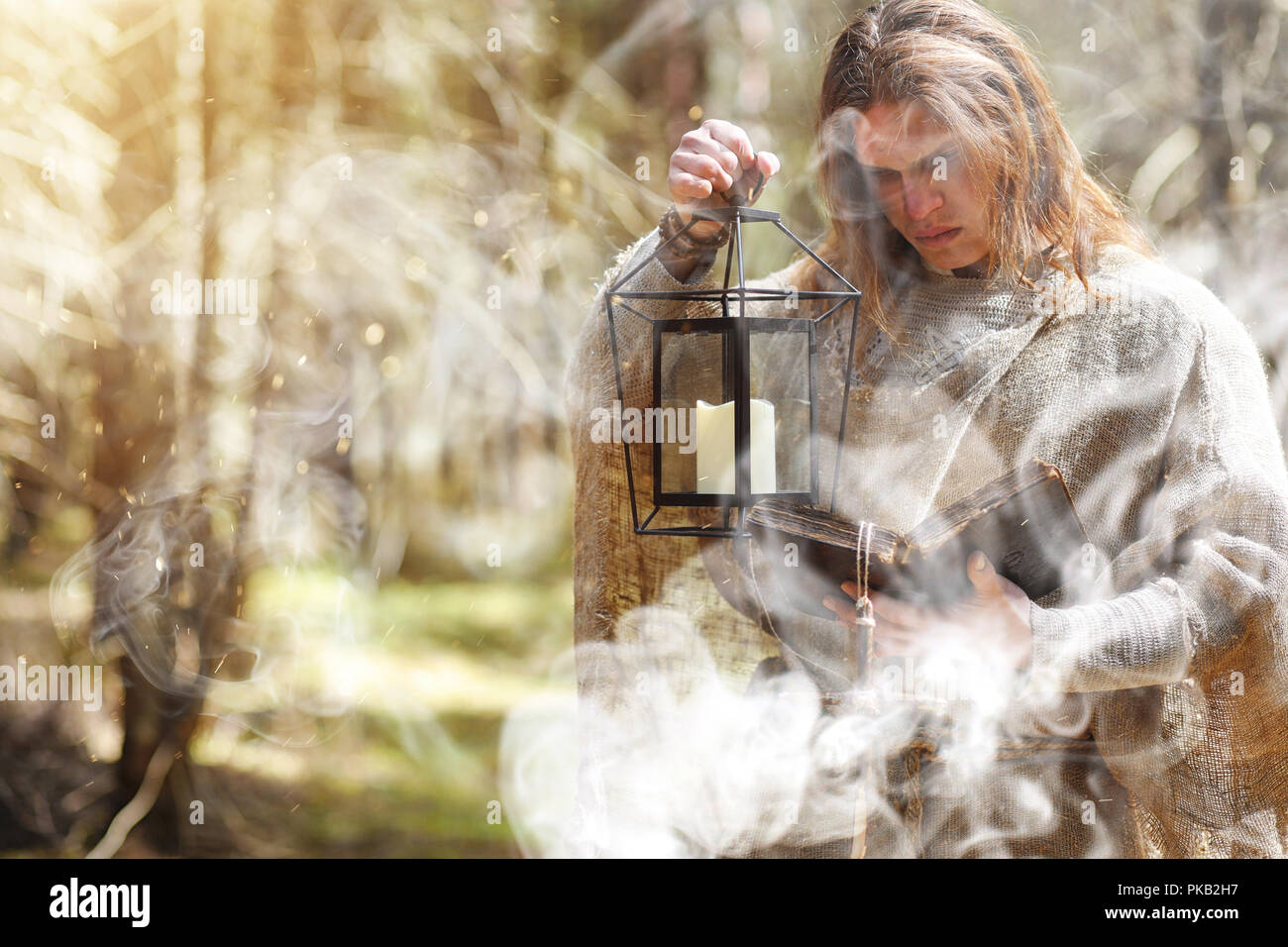 A man in a cassock spends a ritual in a dark forest Stock Photo - Alamy