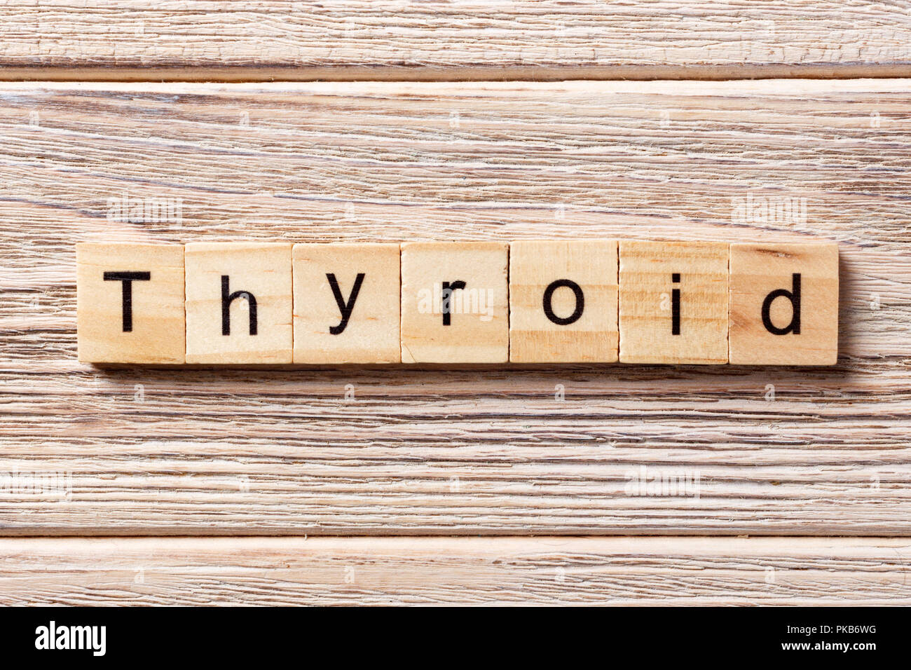 Thyroid word written on wood block. Thyroid text on table, concept ...