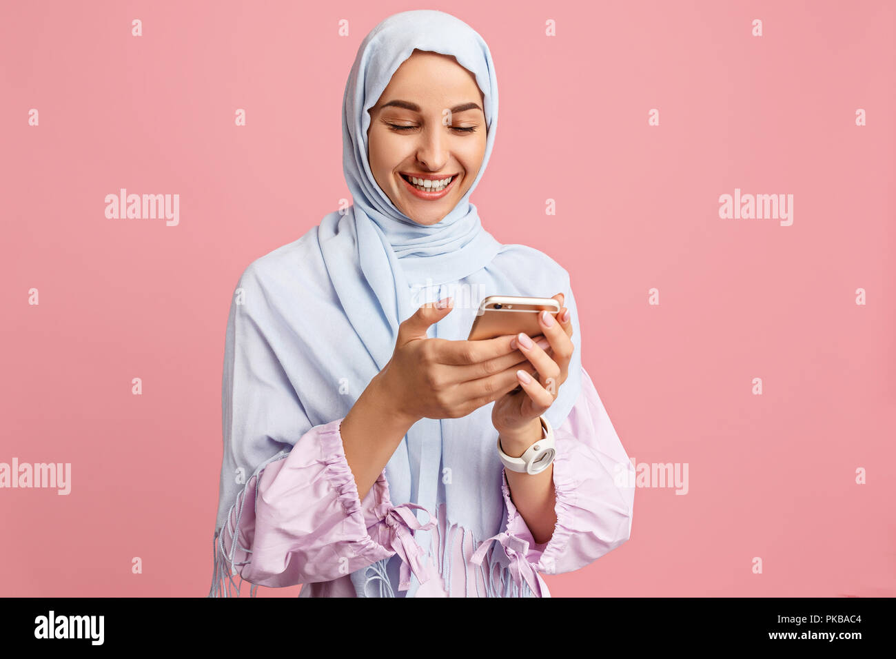 Happy arab woman in hijab with mobile phone. Portrait of smiling girl ...