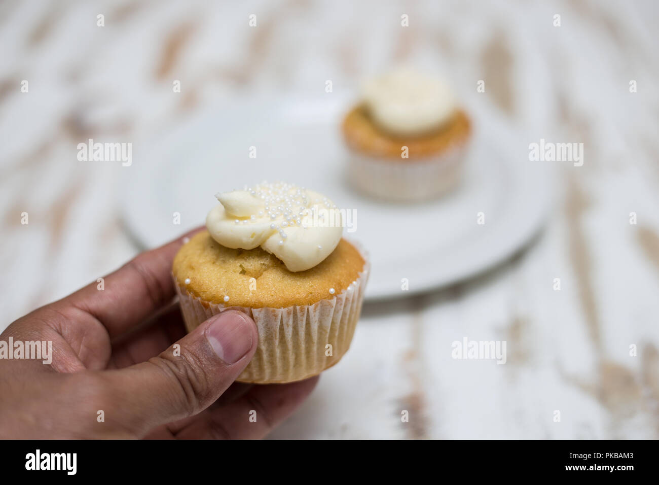Homemade Vanilla Cupcakes with white icing in hand Stock Photo - Alamy