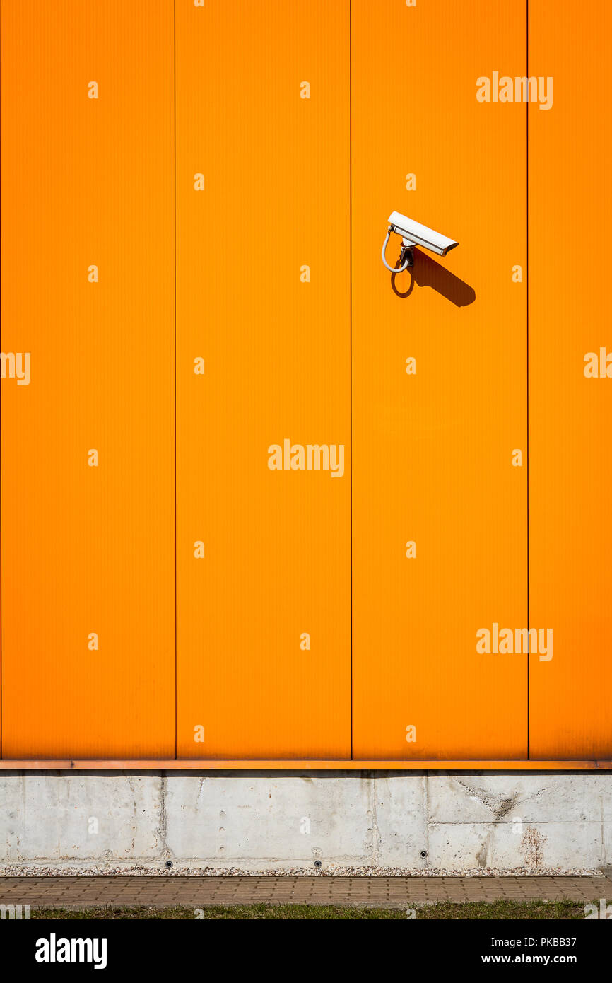 Orange wall of the building, warehouse and the security camera ...