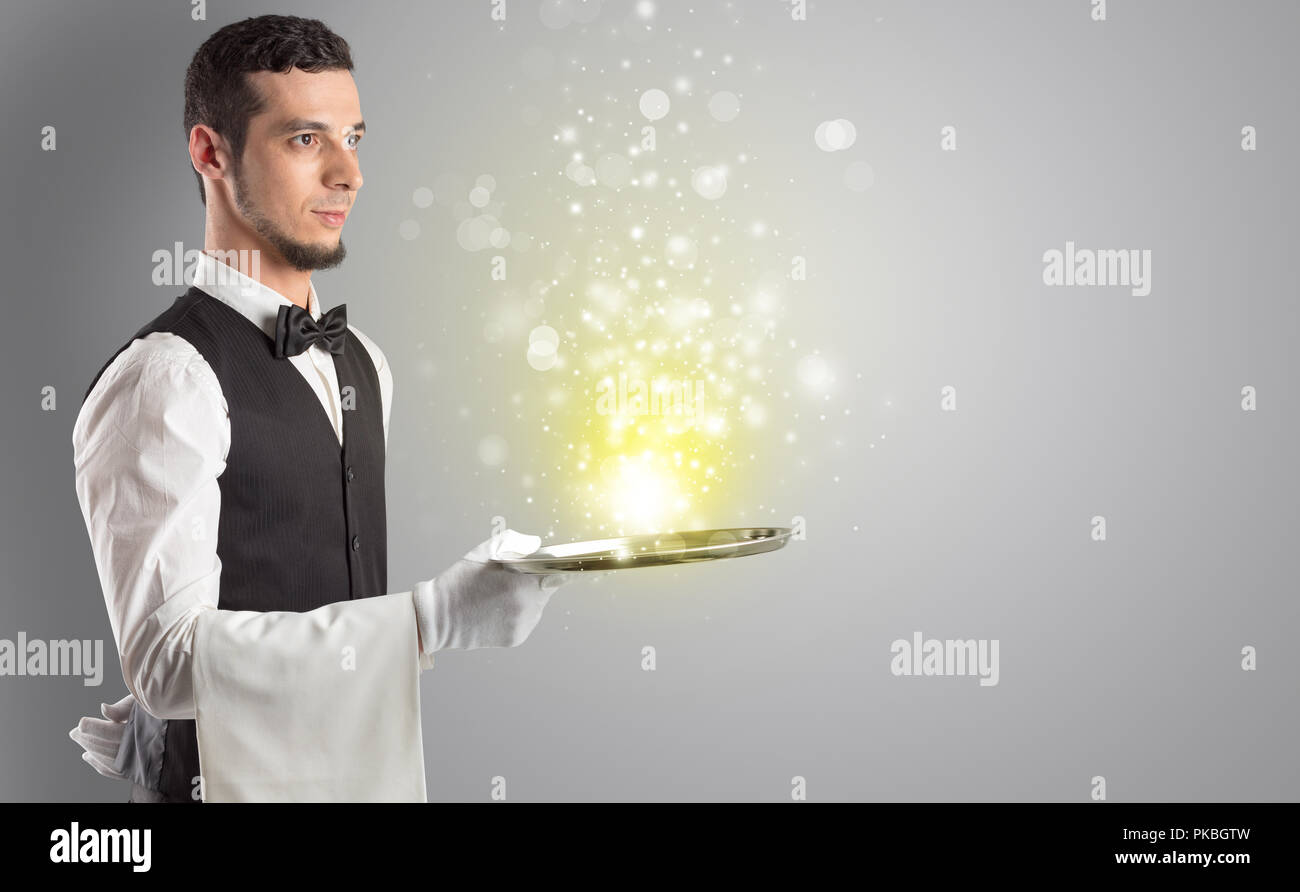 Elegant young waiter serving mysterious light on tray Stock Photo - Alamy