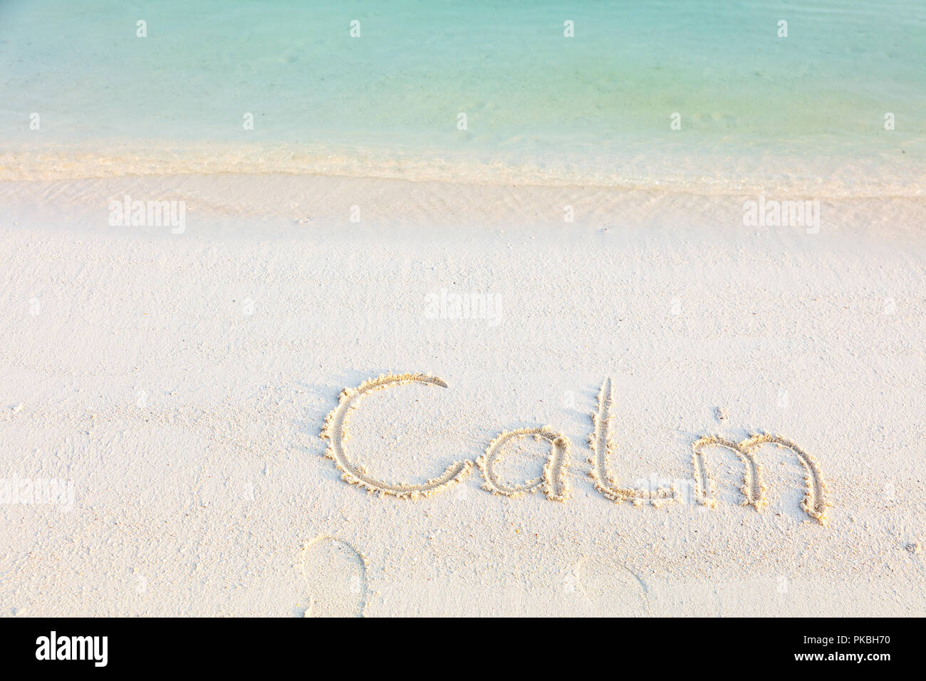 The Word Calm Written in the Sand on a Beach with morning sea ...