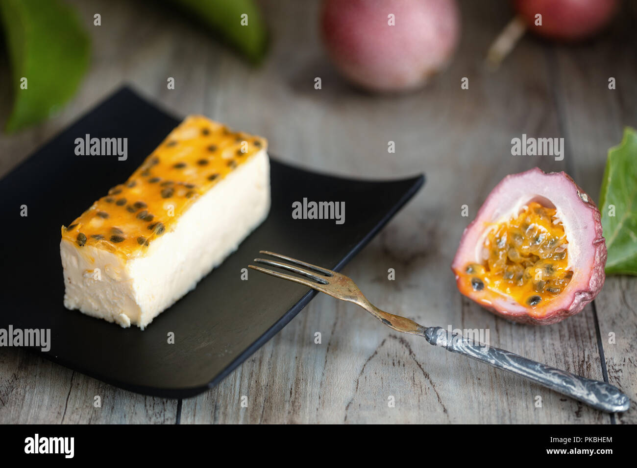 Passion fruits cheese cake slice on dark plate Stock Photo - Alamy