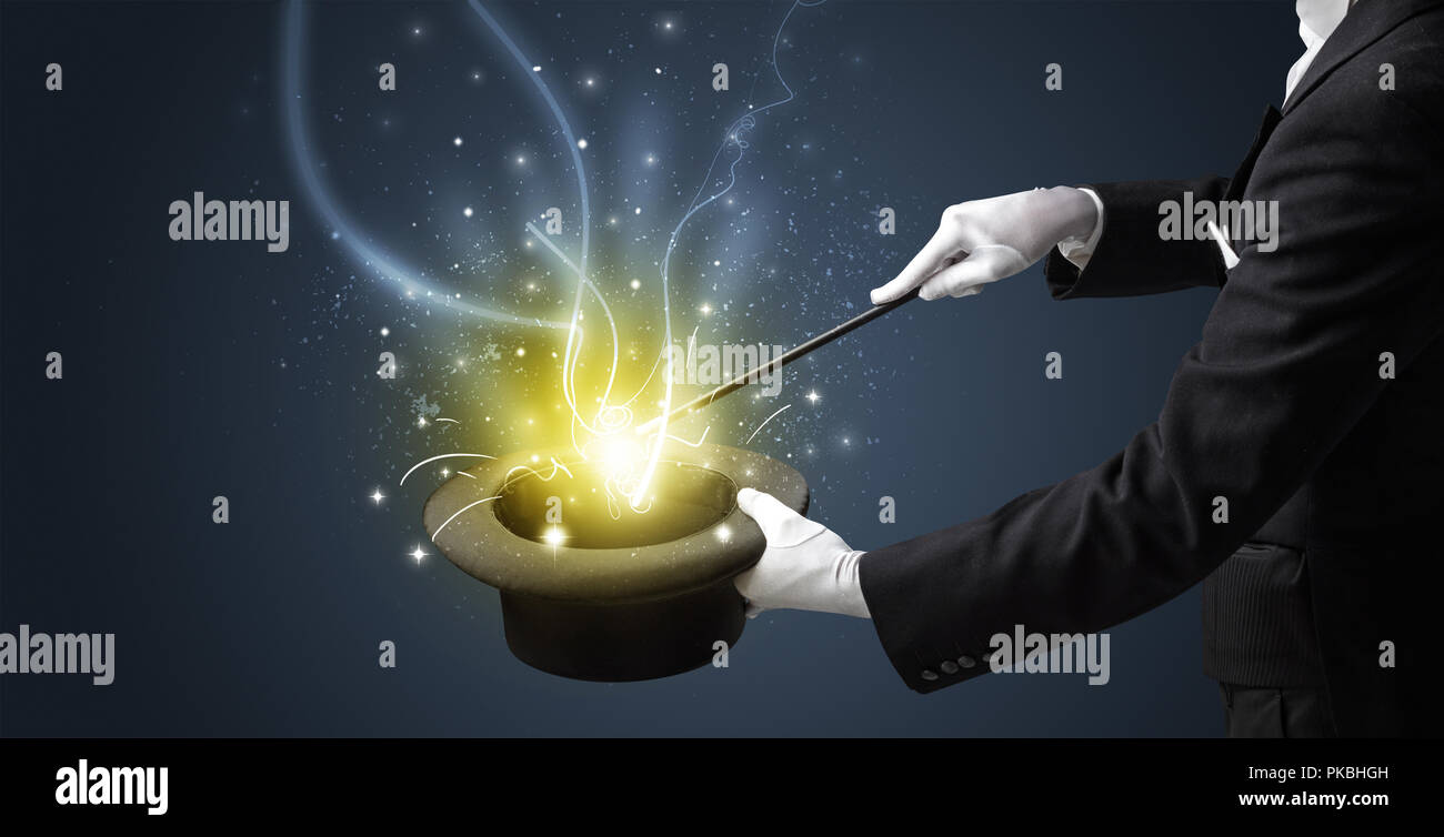 Magician hand conjure with wand light from a black cylinder Stock Photo ...