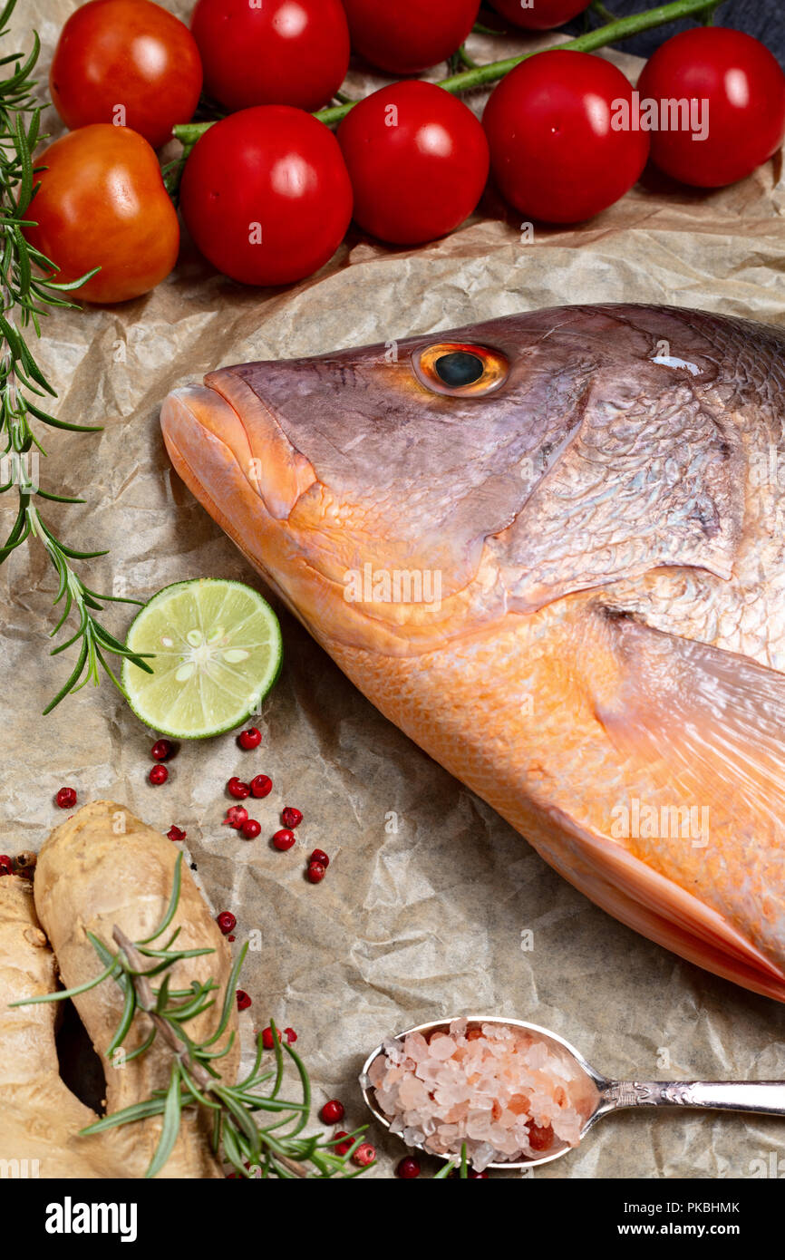 Fresh raw red snapper fish with spices , herbs and vegetables for ...
