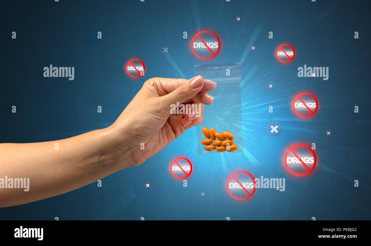 Hand giving pills with anti-drug concept and not allowed signs around ...