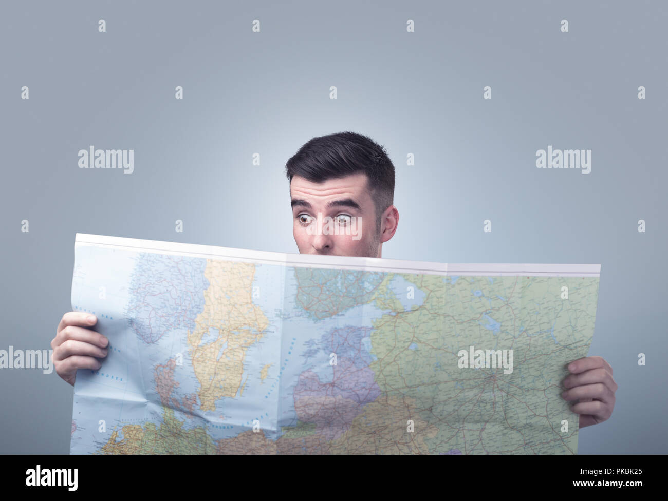 Handsome young man holding map Stock Photo - Alamy