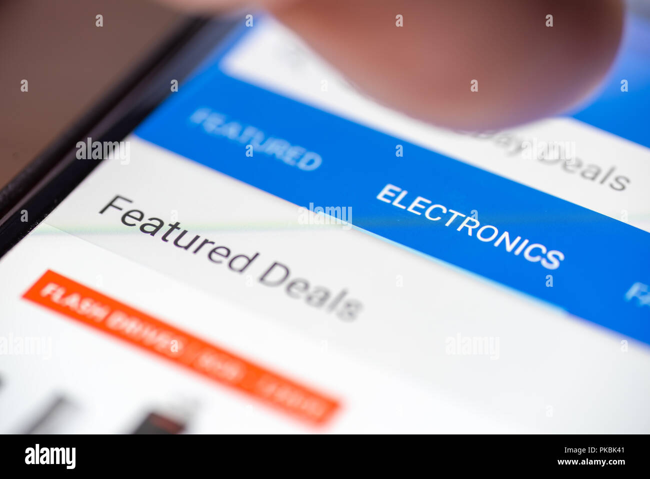 Human finger thumb over Electronics category button link on shopping ...