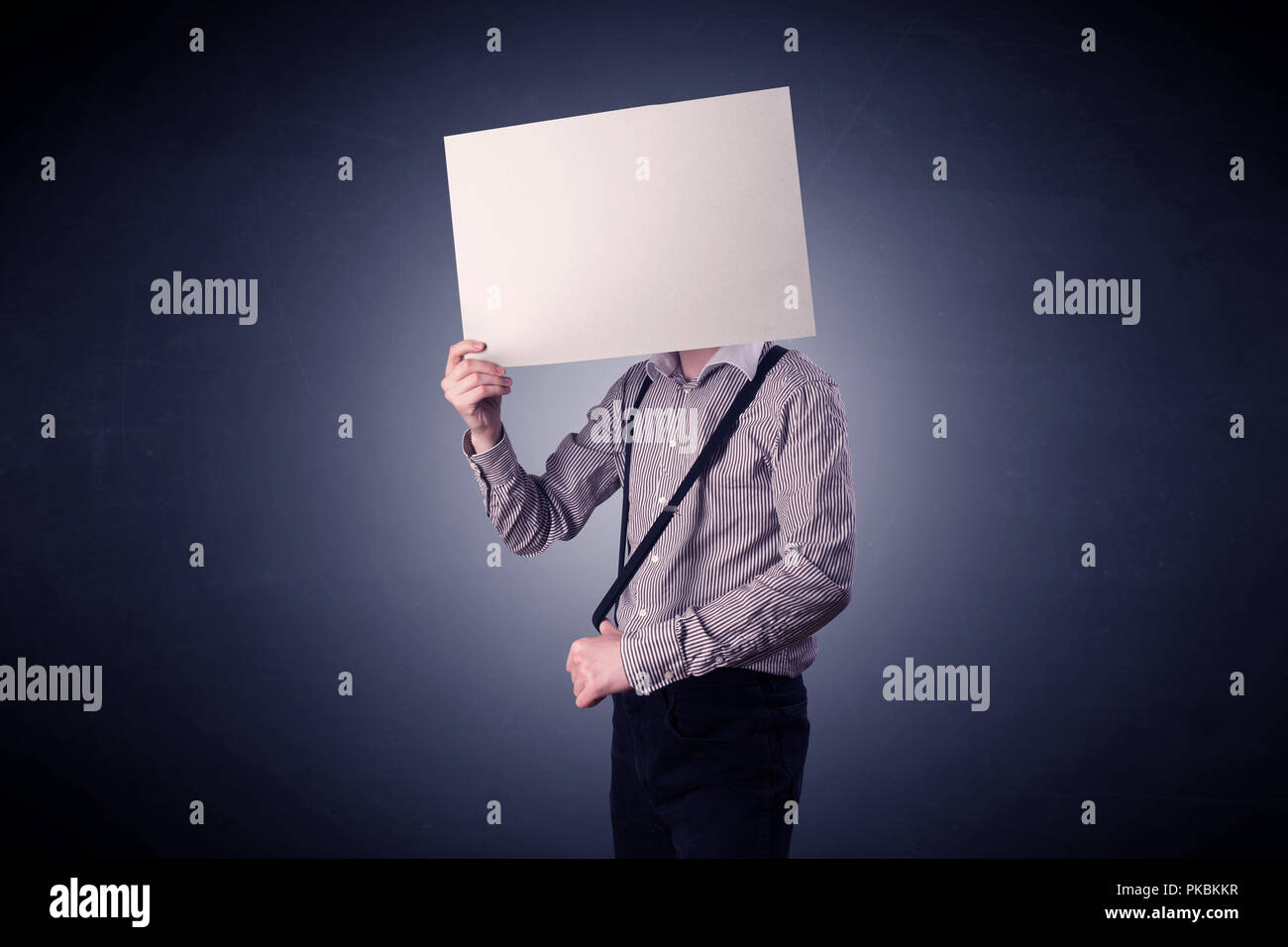 Young businessman hiding behind a blank piece of paper Stock Photo - Alamy