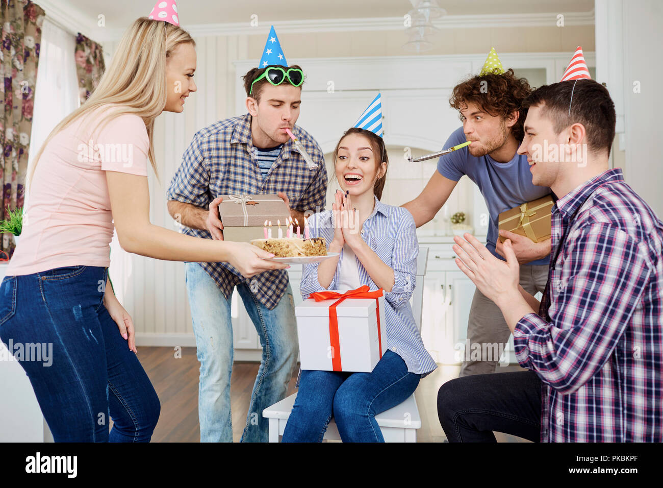 Friends with cake celebrating birthday at a party Stock Photo - Alamy