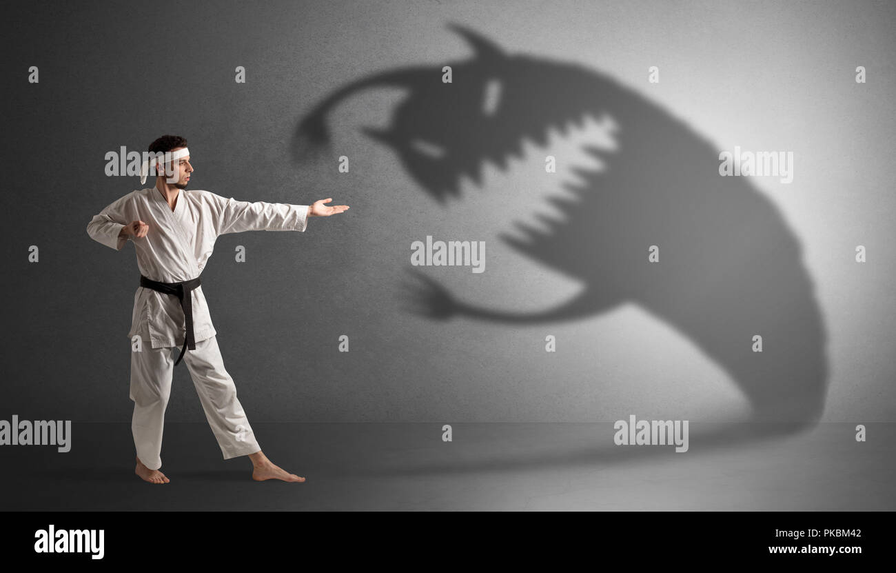 Young karate man fighting with a big black scary shadow Stock Photo - Alamy