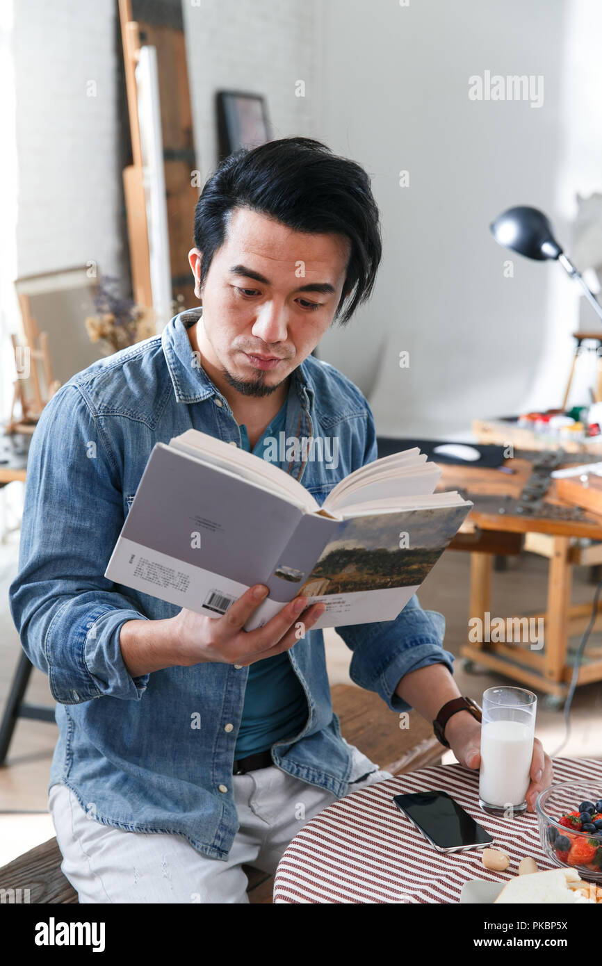 Male artist reading Stock Photo - Alamy
