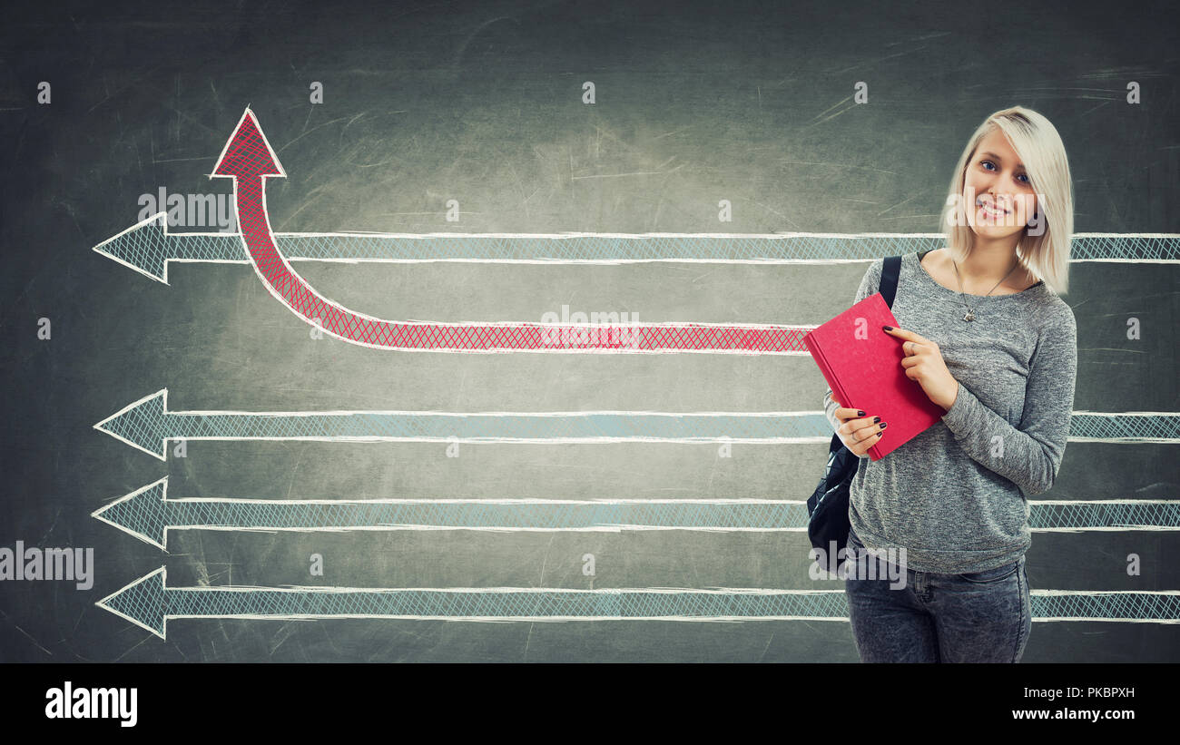 Young student woman holding a red book over blackboard background ...