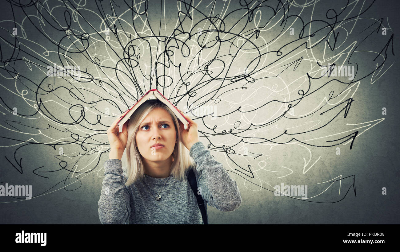 Confused young woman student holding a opened book over head. Sad ...