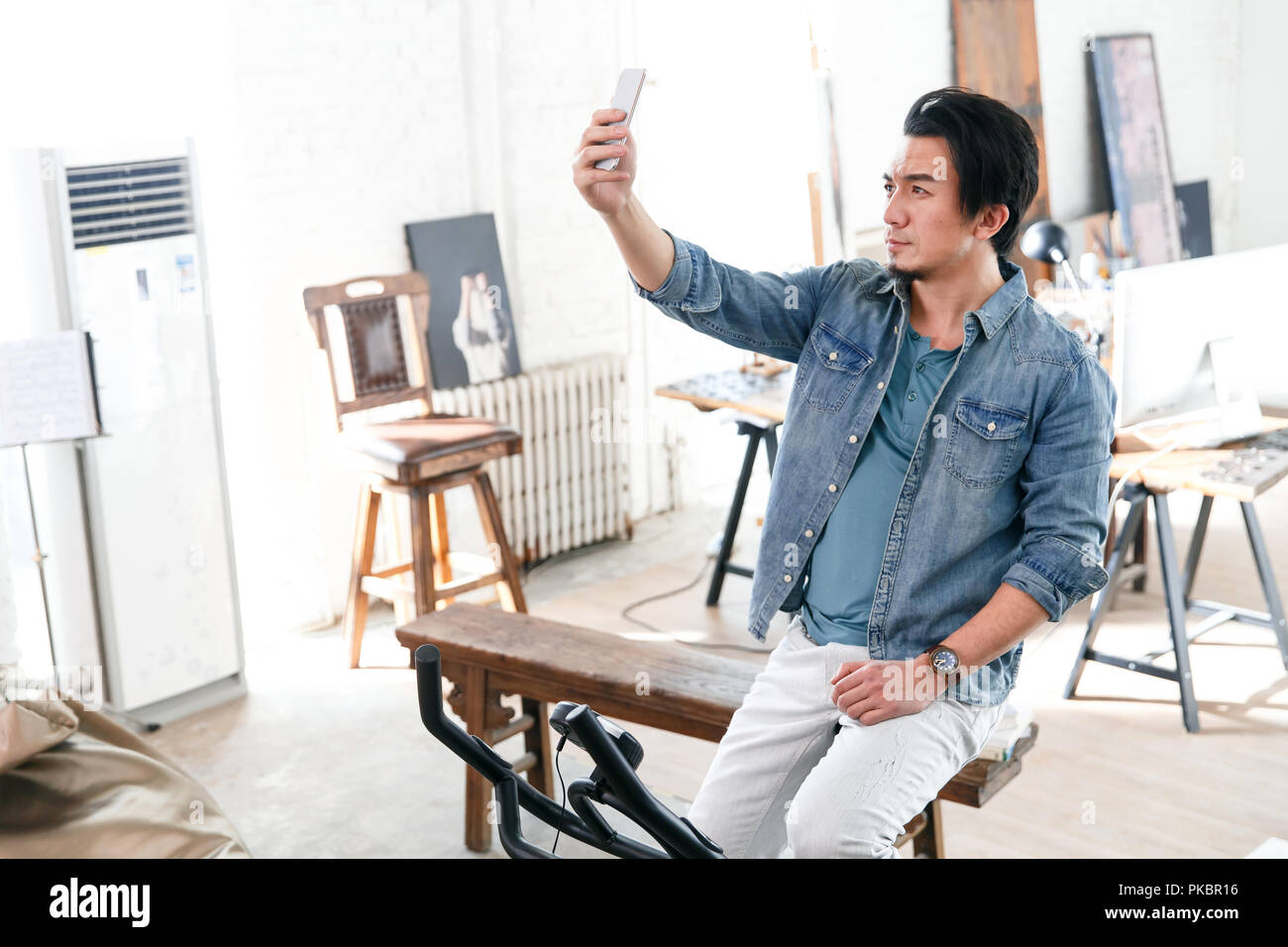 Male artist holding a mobile phone Stock Photo - Alamy