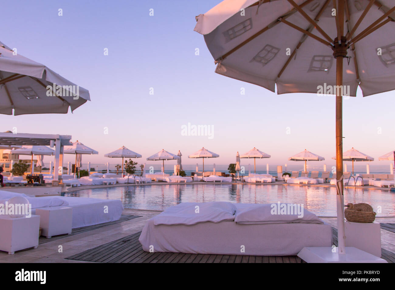 Pastel Sunset Light over Swimming Pool and Sun Beds Stock Photo - Alamy