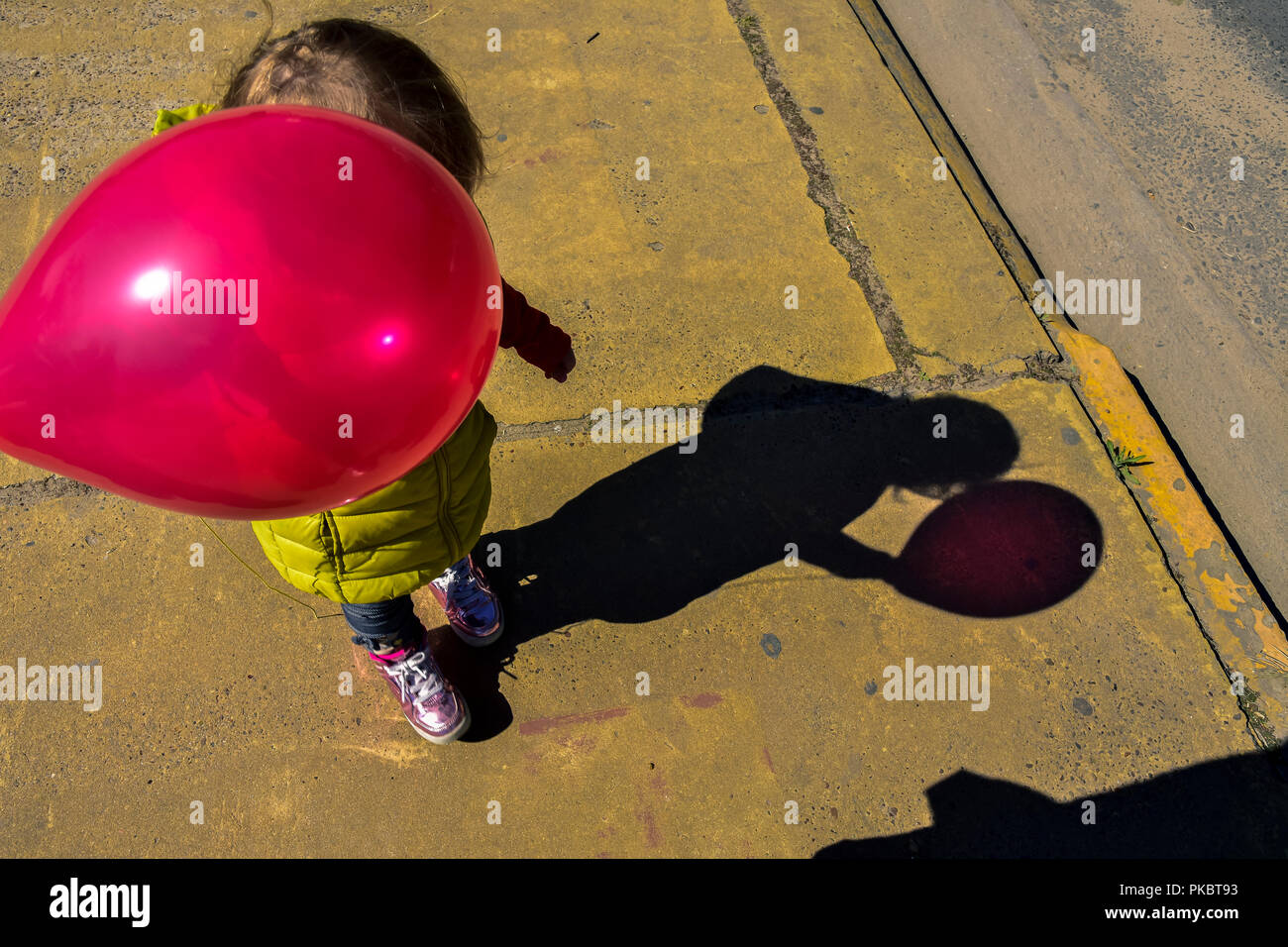 Little girl playing with a balloon and her shadow Stock Photo - Alamy