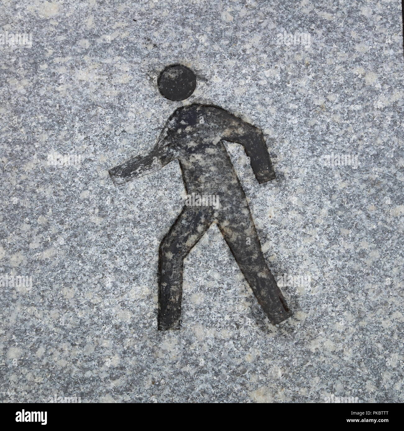 A very carefully carved paving slab in Granite with a walking man ...