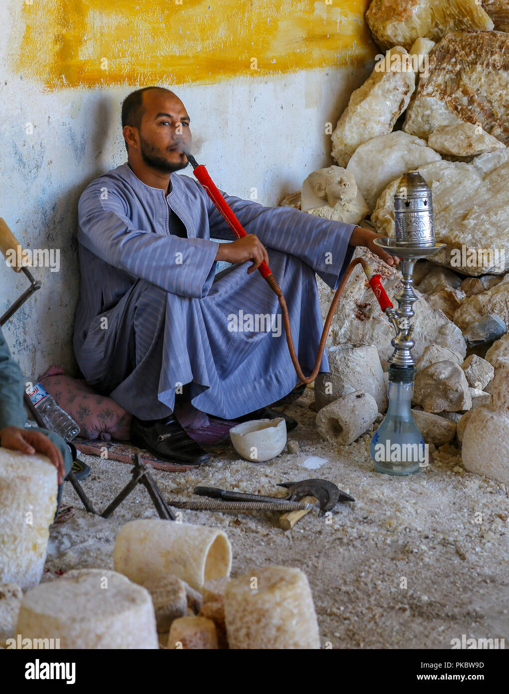 A worker at an Alabaster factory and shop having a break and smoking a ...