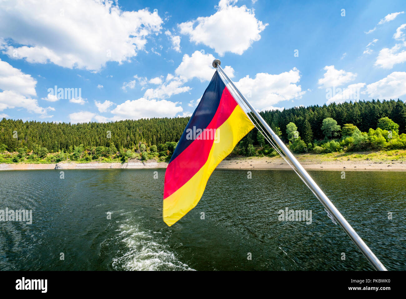 German flag on a boat in the summer waving in the wind over a lake ...