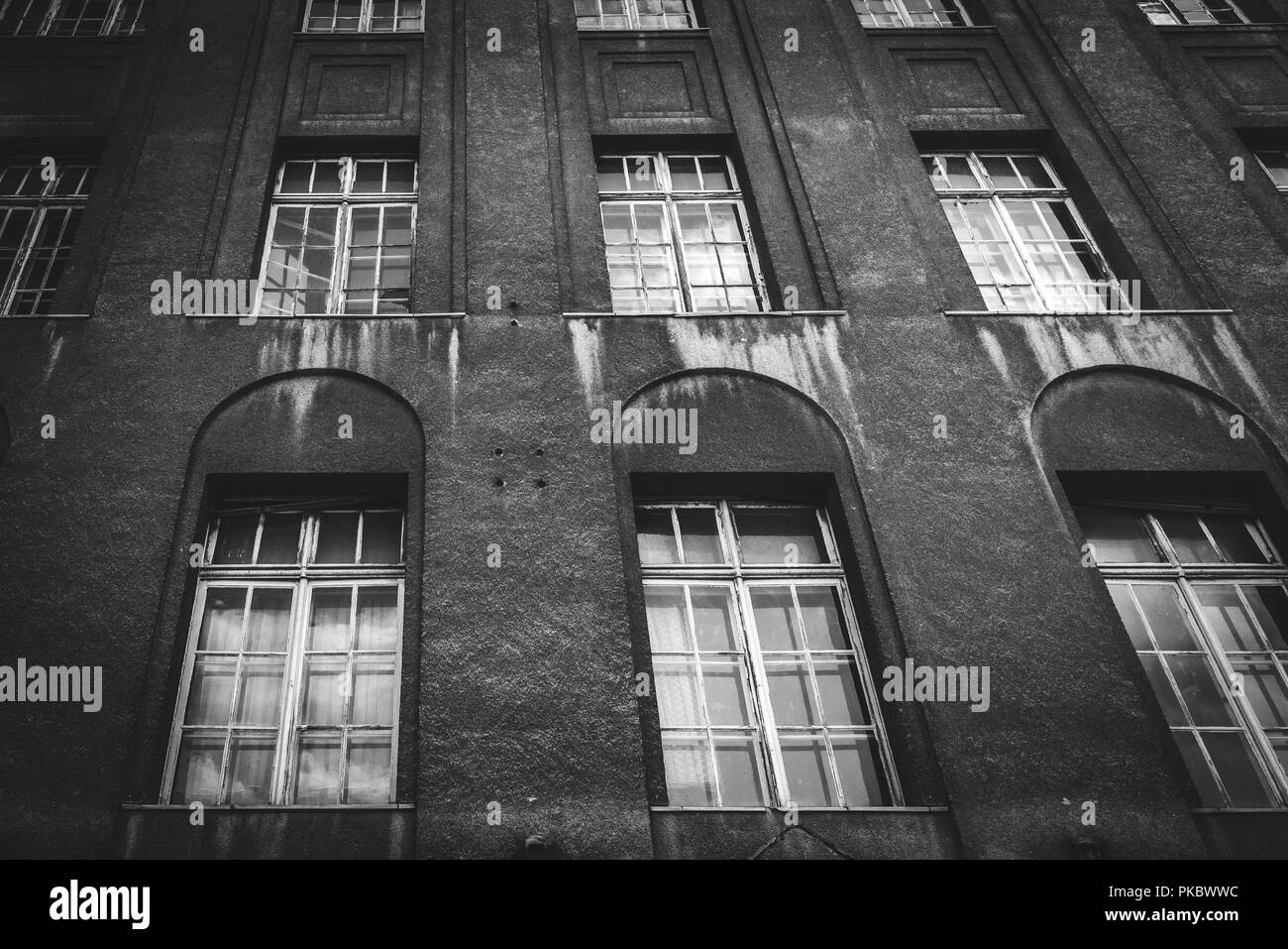 Dark building with tall windows in weathered conditions looking spooky ...