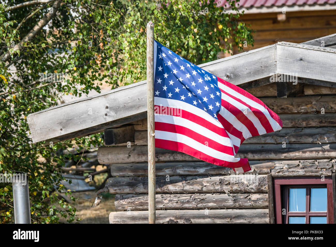 The flag of USA outside a wooden cabin in the wild west Stock Photo - Alamy