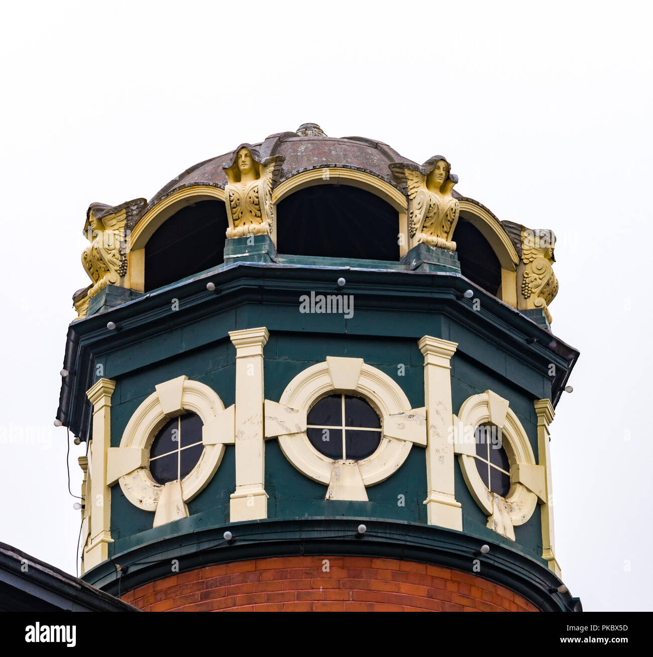 The turreted top of a building with angels and circular windows in ...
