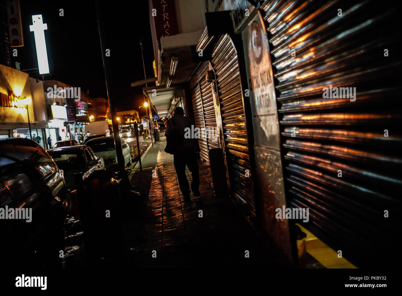. A man walks on the sidewalk and dark streets. Daily life in the ...
