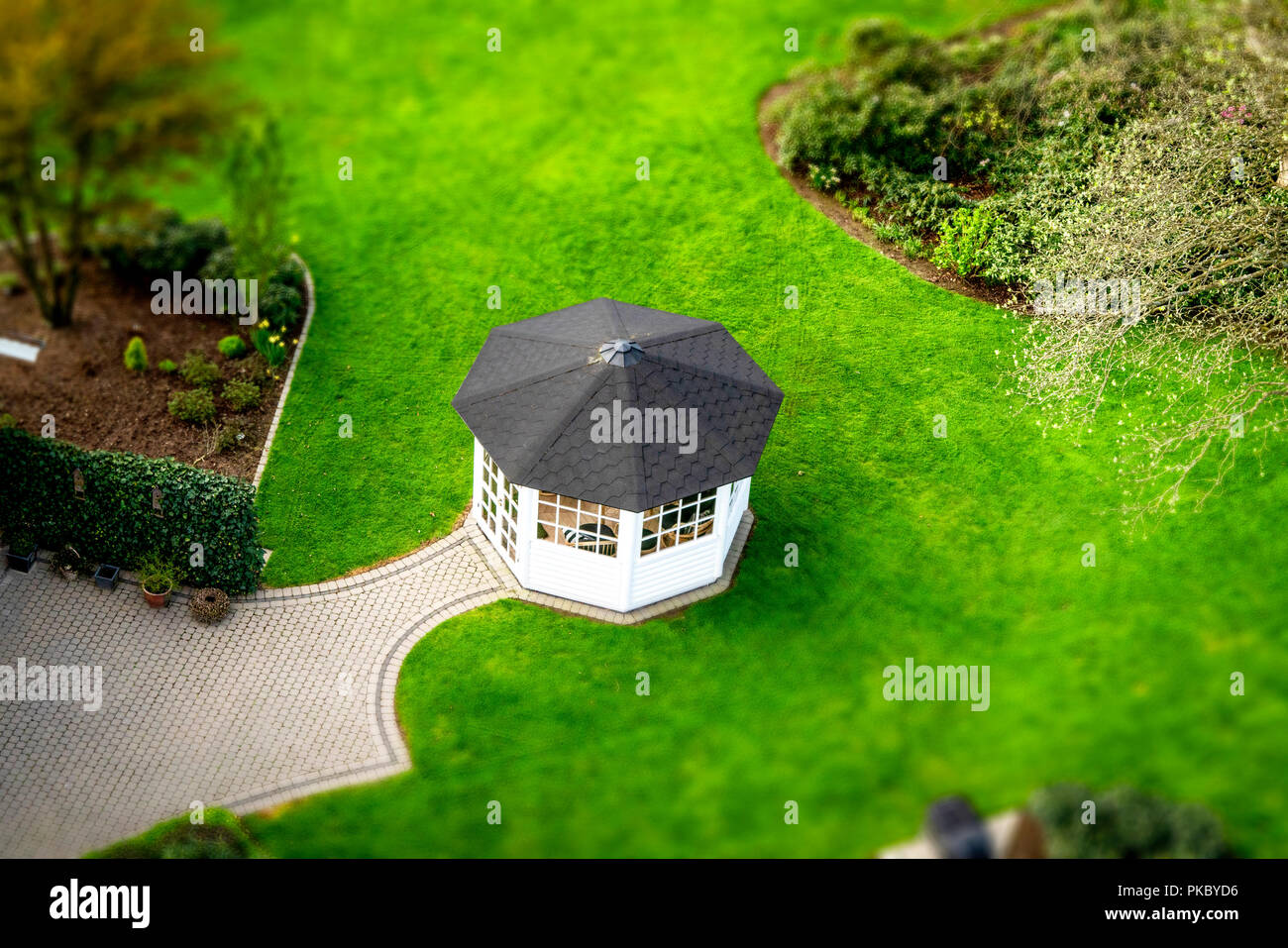 Small pavillon in a garden on a green lawn in the spring seen from ...