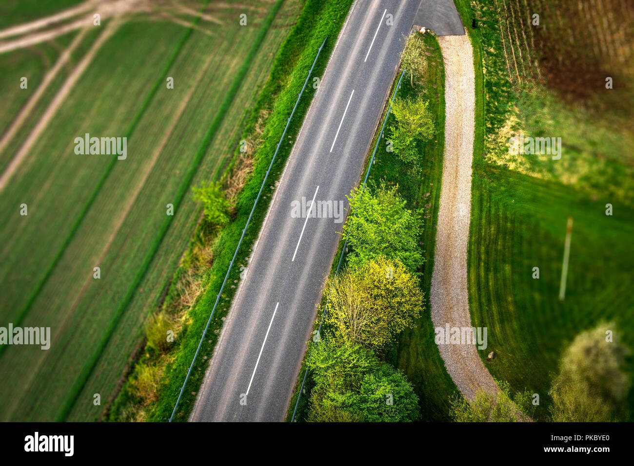 Highway asphalt road seen from above with trees and meadows along the ...