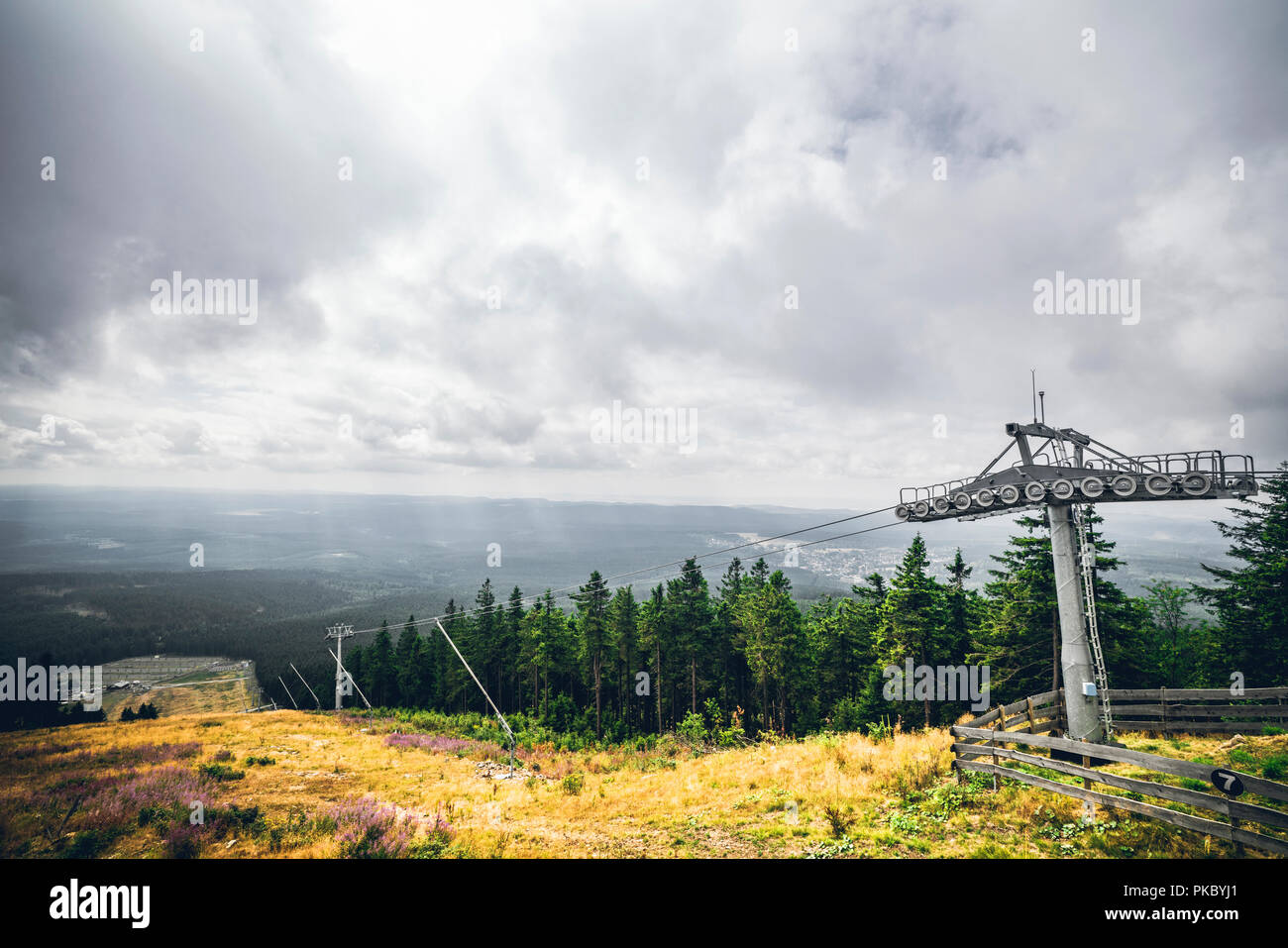 Mountain lift in the summer with a view over a valley in cloudy weather ...