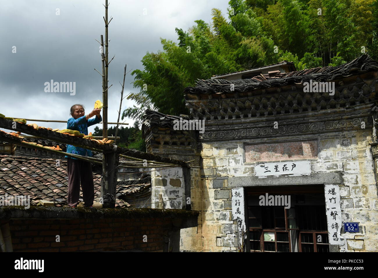 Shaowu. 12th Sep, 2018. A villager airs crops at a traditional house in ...