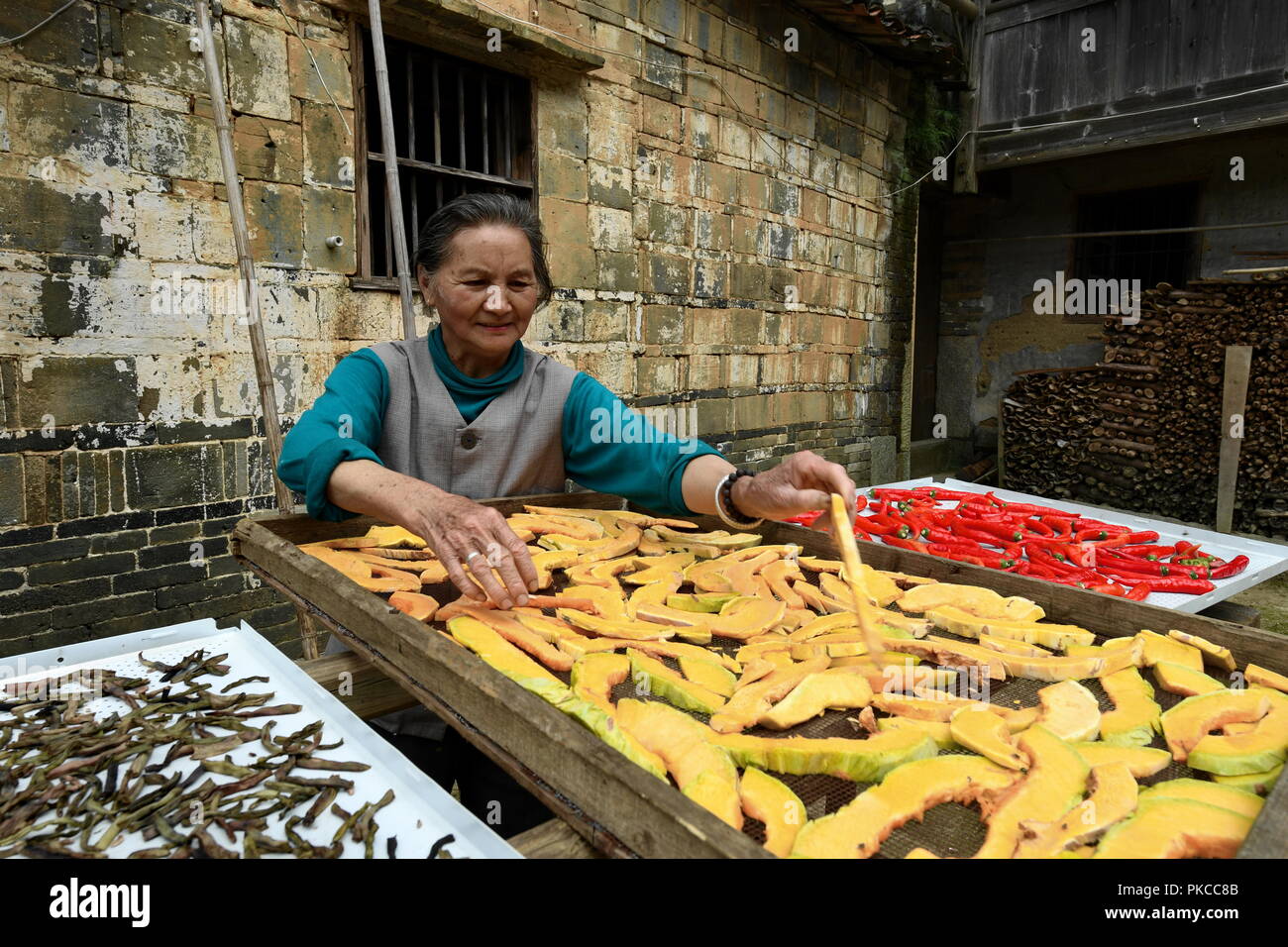 Shaowu. 12th Sep, 2018. A villager airs crops at a traditional house in ...