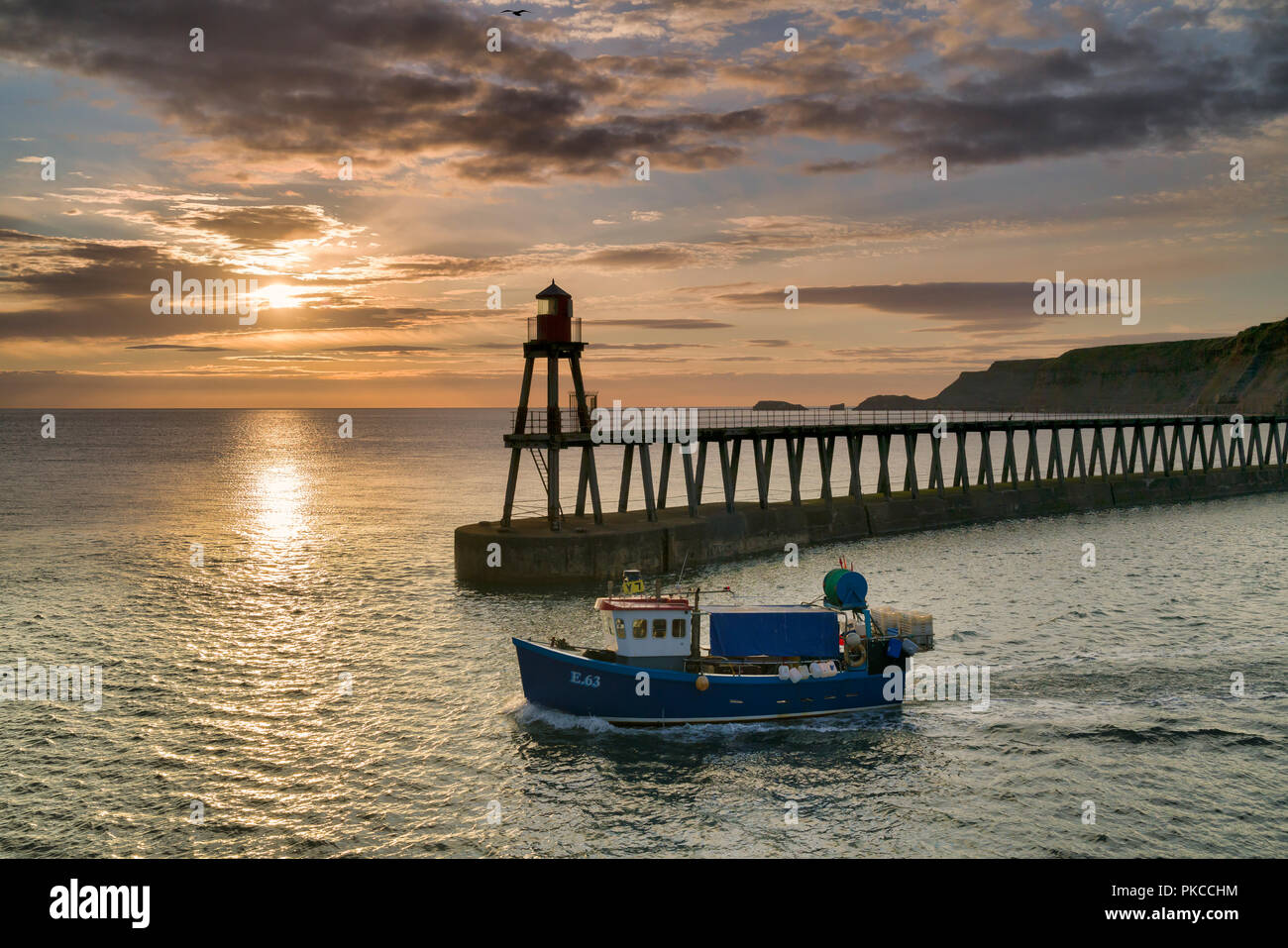 Whitby, UK. 13th Sep 2018. UK Weather: Sun rising over Whitby East Pier ...