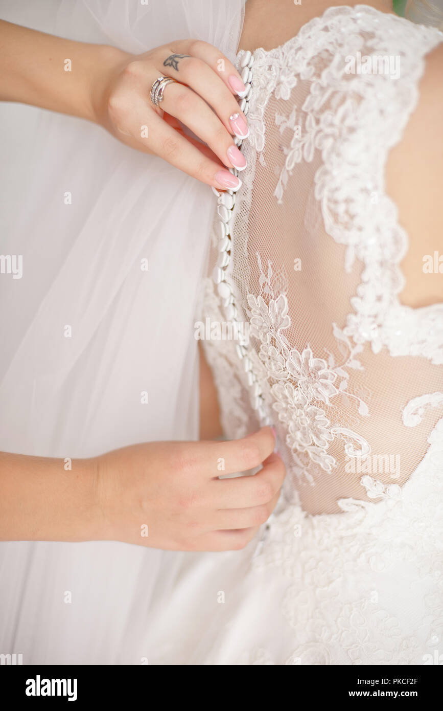 Close-up female hands on waist. Woman wearing in wedding dress holding ... Close-up female hands on waist. Woman wearing in wedding dress holding ...