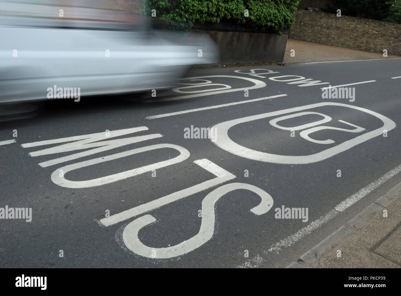 vehicle seen in blurred motion passing road markings denoting a 20mph ...