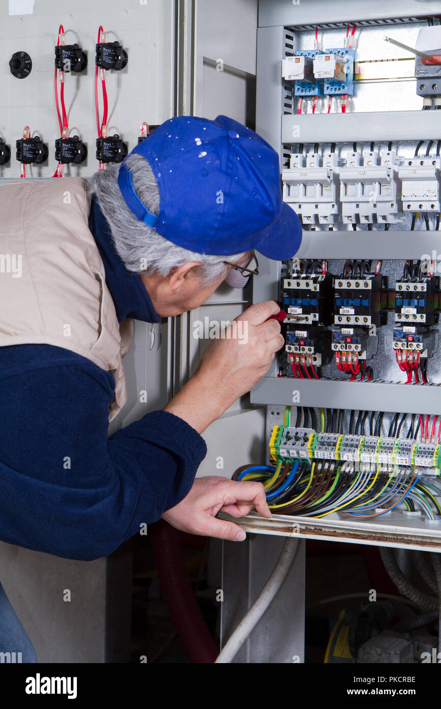 electrician at work with an electric panel Stock Photo - Alamy