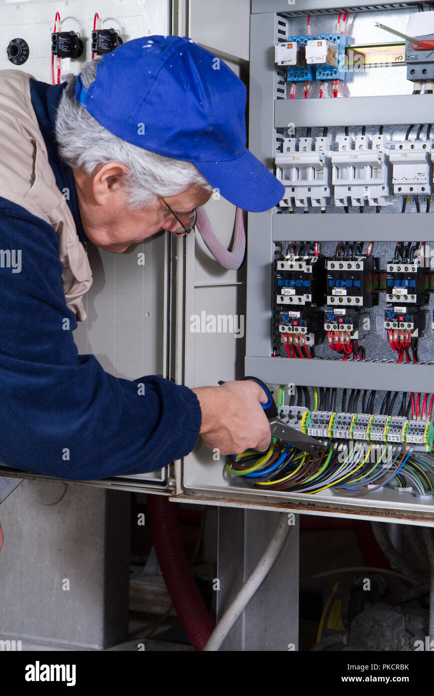 electrician at work with an electric panel Stock Photo - Alamy