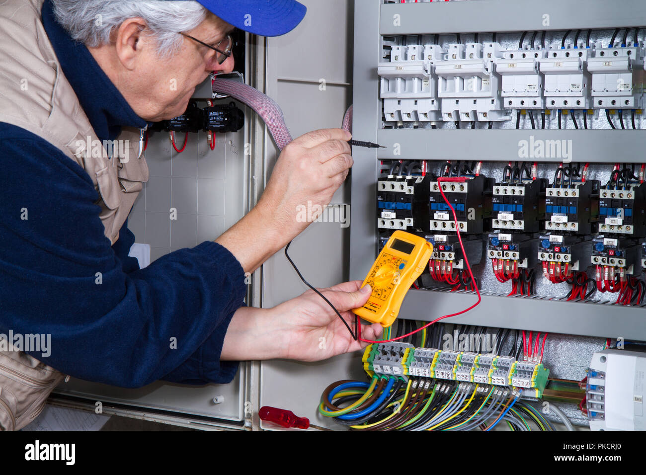 electrician at work with an electric panel Stock Photo - Alamy